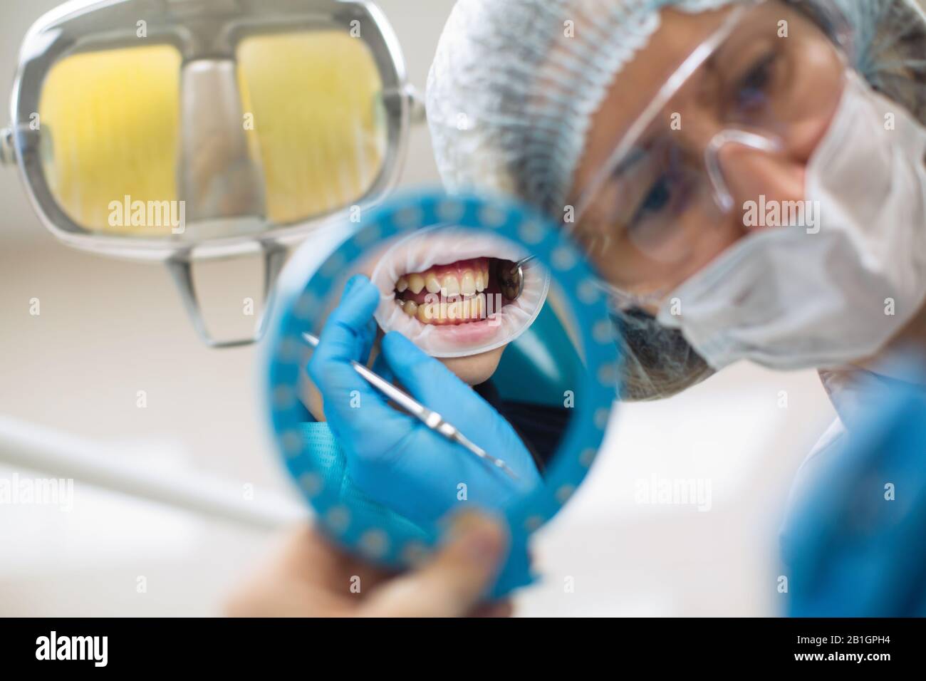 Reflection in the mirror mouth and teeth, woman dentist doing teeth ...