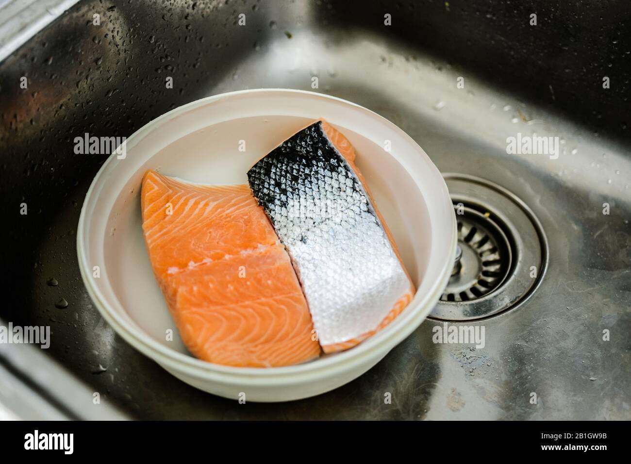 Overhead view of kitchen stainless steel sink with plastic bowl ...