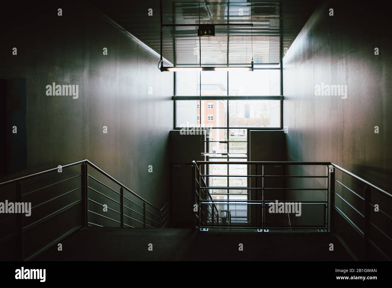 Abstract empty corridor with large downward staircase and large glass ...