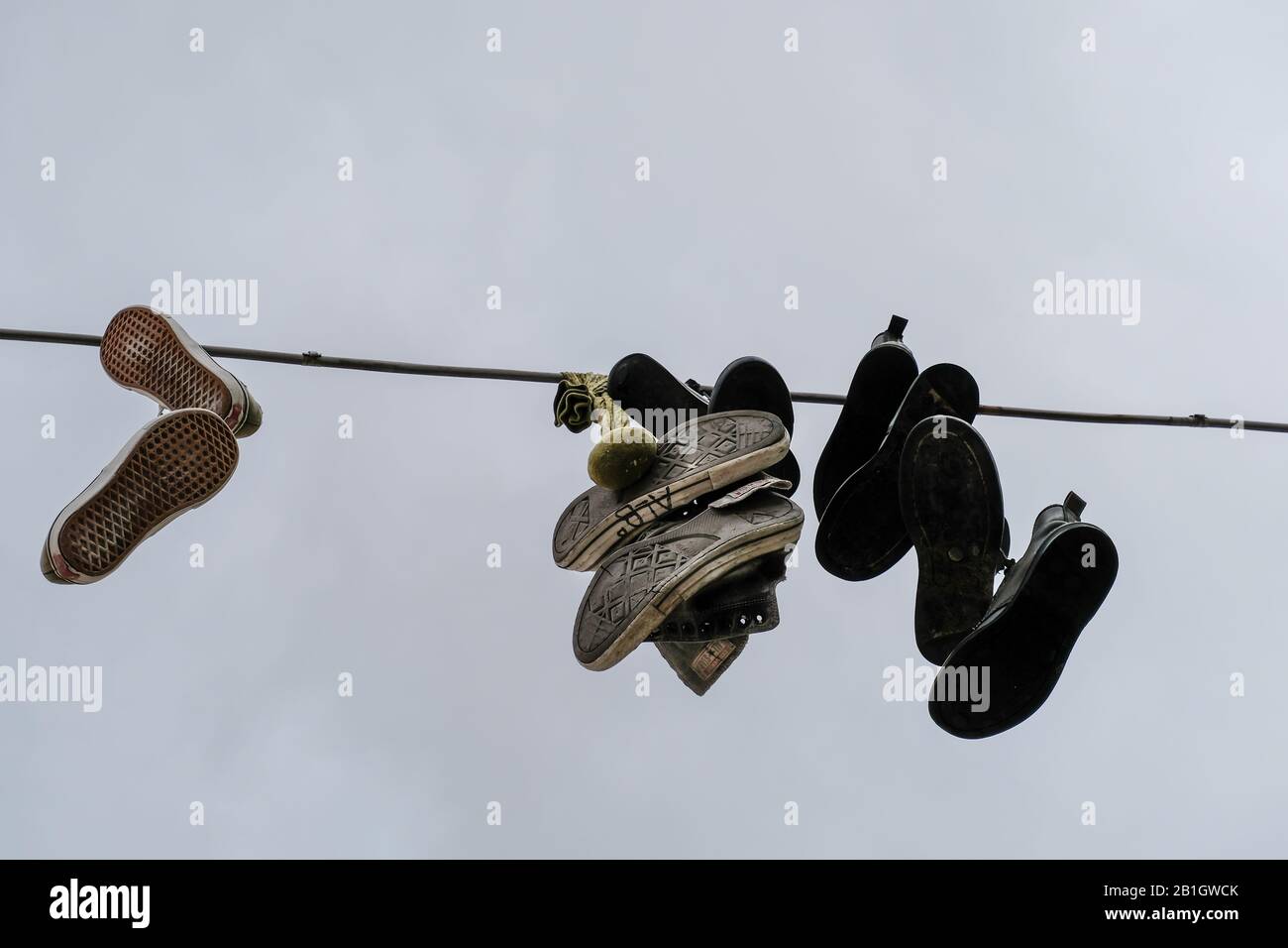 Hanging sneakers shoes over bright cloudy sky,urban city art symbol ...