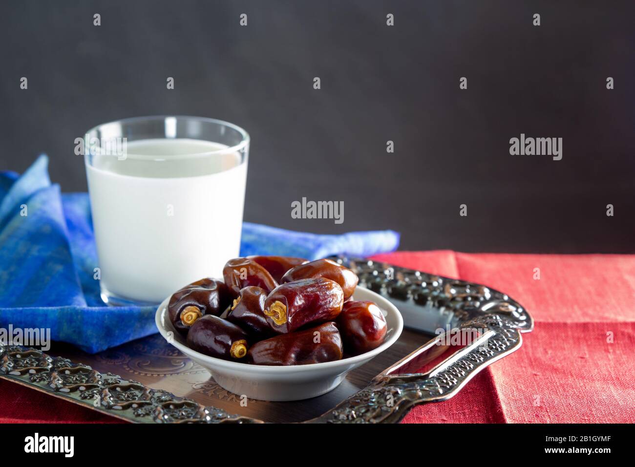 Dates and a glass of milk on metal tray and colorful napkins. Ramadan ...