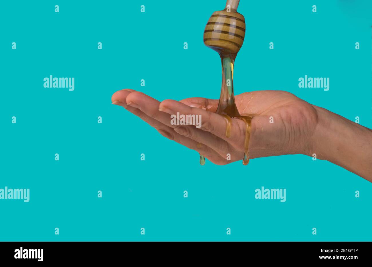 Human hand full of honey isolated on a cyan blue background Stock Photo ...