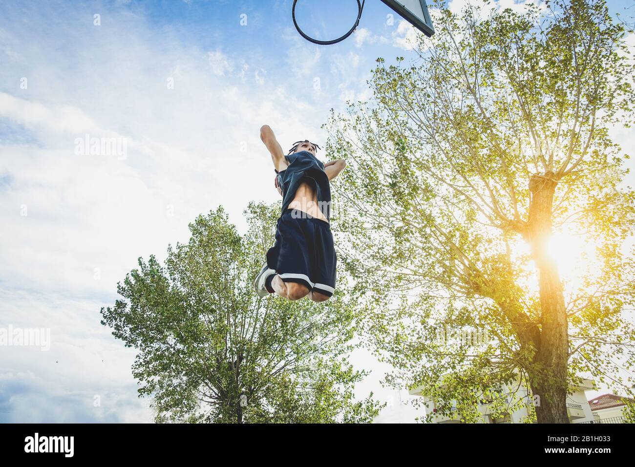 Basketball athlete doing huge slam dunk on the court in urban grunge ...