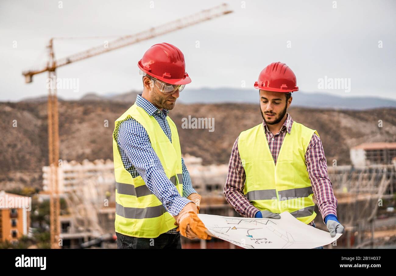 Builders on residential construction site looking the building project ...