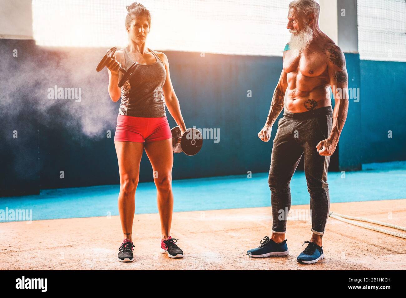 Fit woman with dumbbells in functional training fitness gym - Tattooed ...