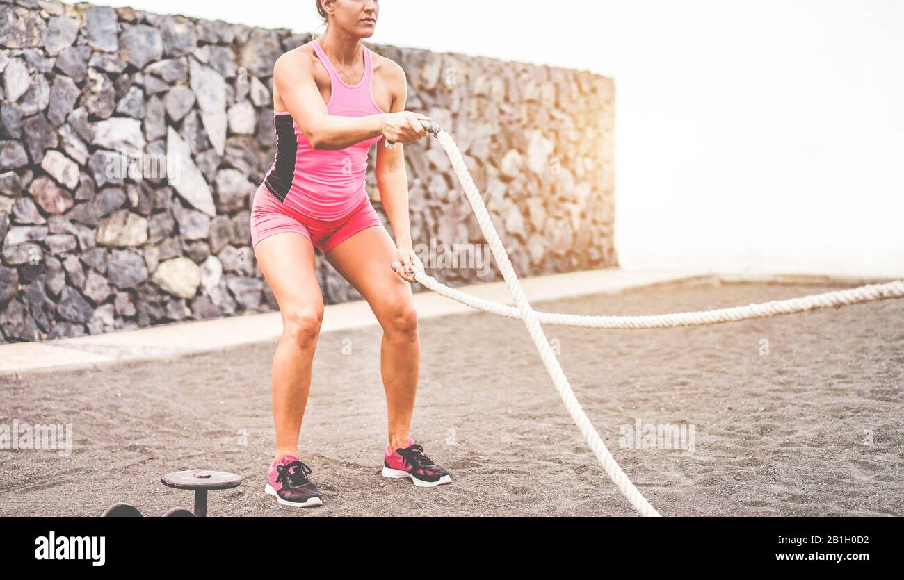 Fit woman with battle rope outdoor - Female athlete doing workout ...