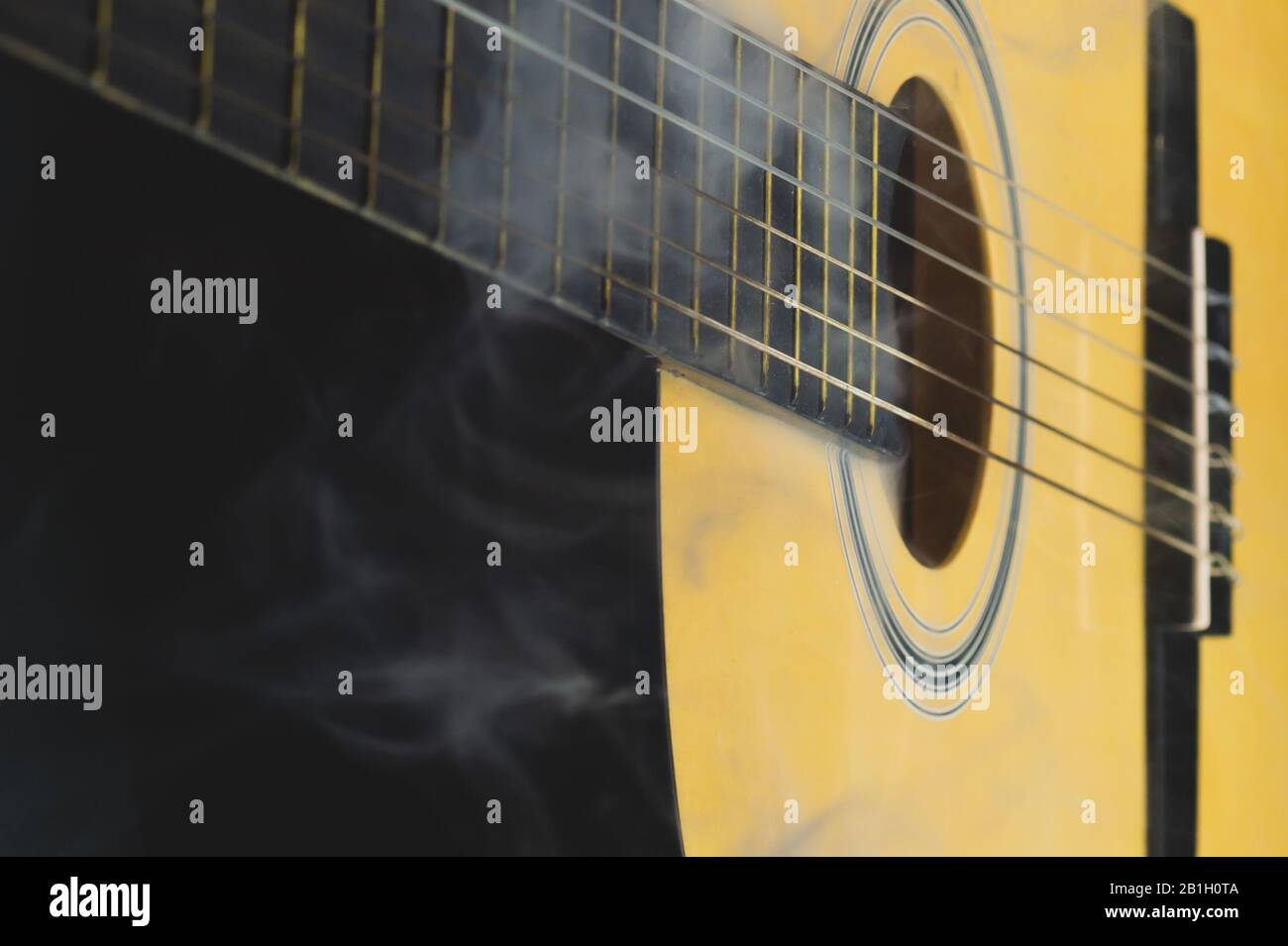 Guitar in smoke close up. acoustic musical instrument. strings on the ...