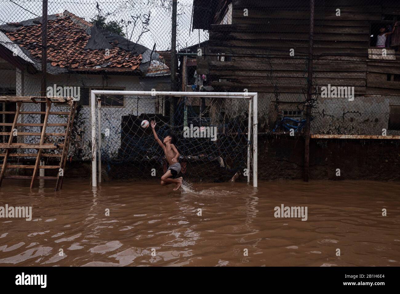A boy playing football at a flooded pitch.Heavy rains triggered ...