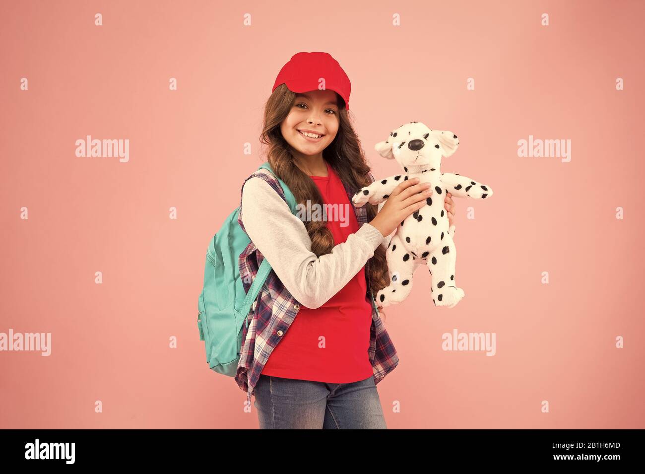 Favorite toy. Happy small child hold soft toy on pink background ...