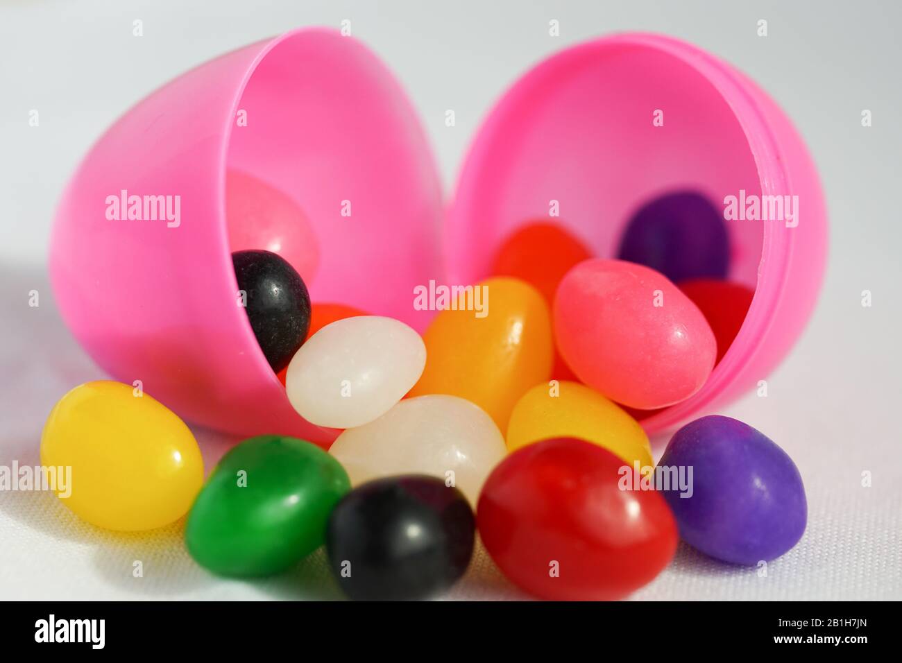Colorful jelly beans spill out of plastic Easter eggs Stock Photo - Alamy