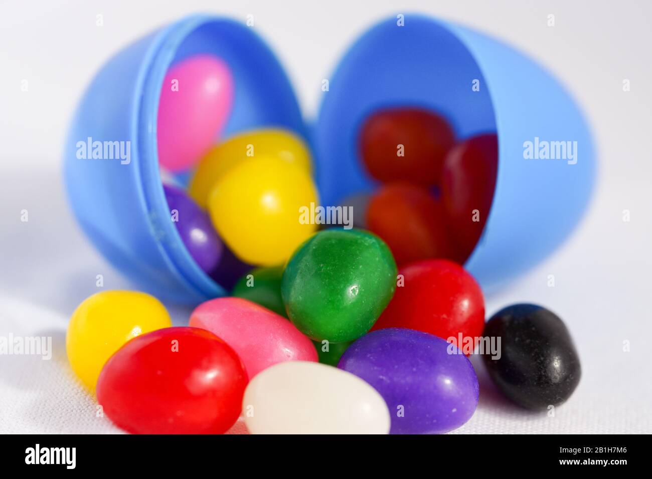 Colorful jelly beans spill out of plastic Easter eggs Stock Photo - Alamy
