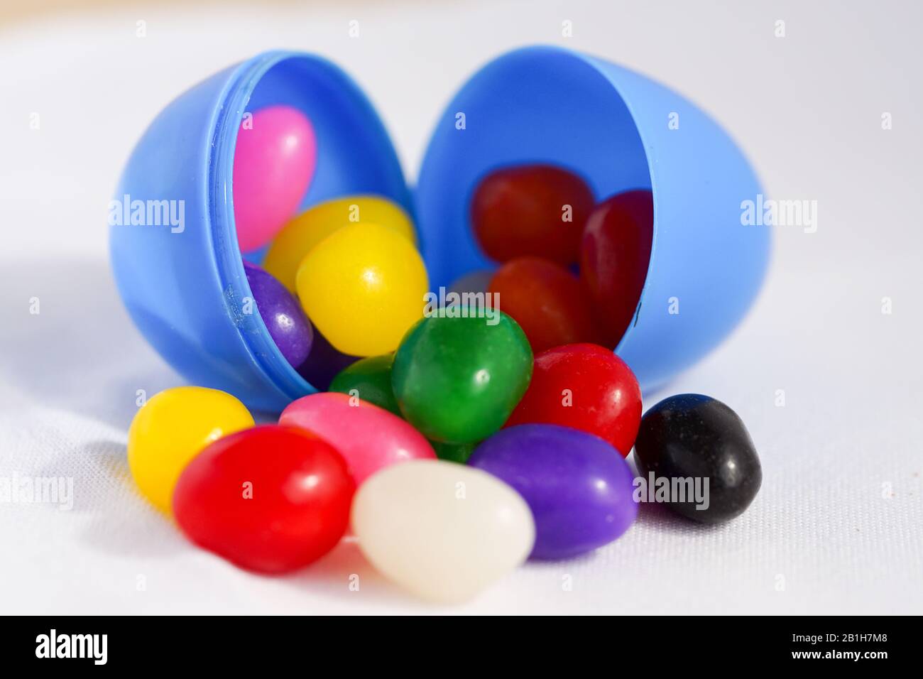 Colorful jelly beans spill out of plastic Easter eggs Stock Photo - Alamy