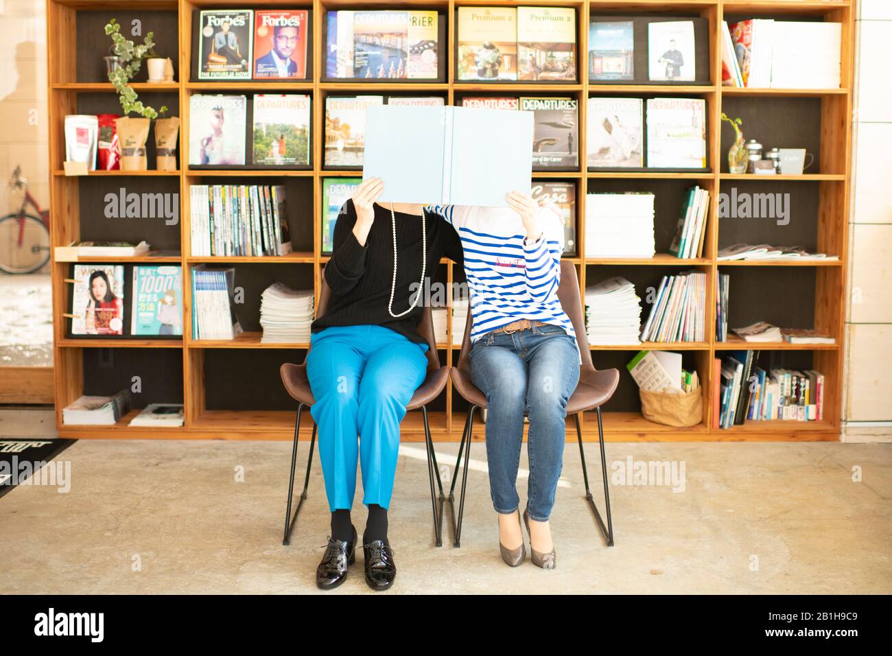 Two women reading book Stock Photo - Alamy