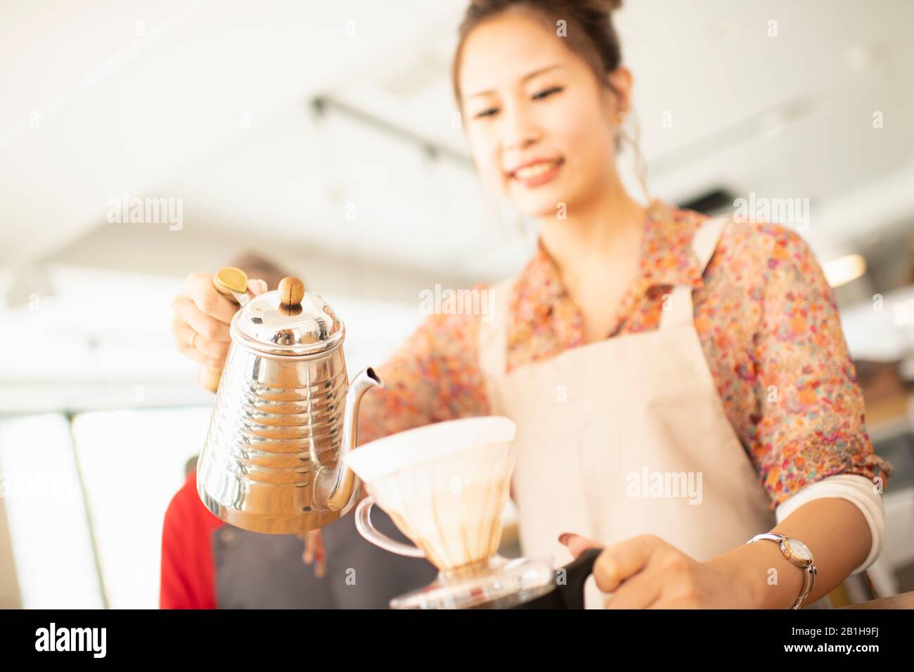 Woman making coffee at counter Stock Photo - Alamy