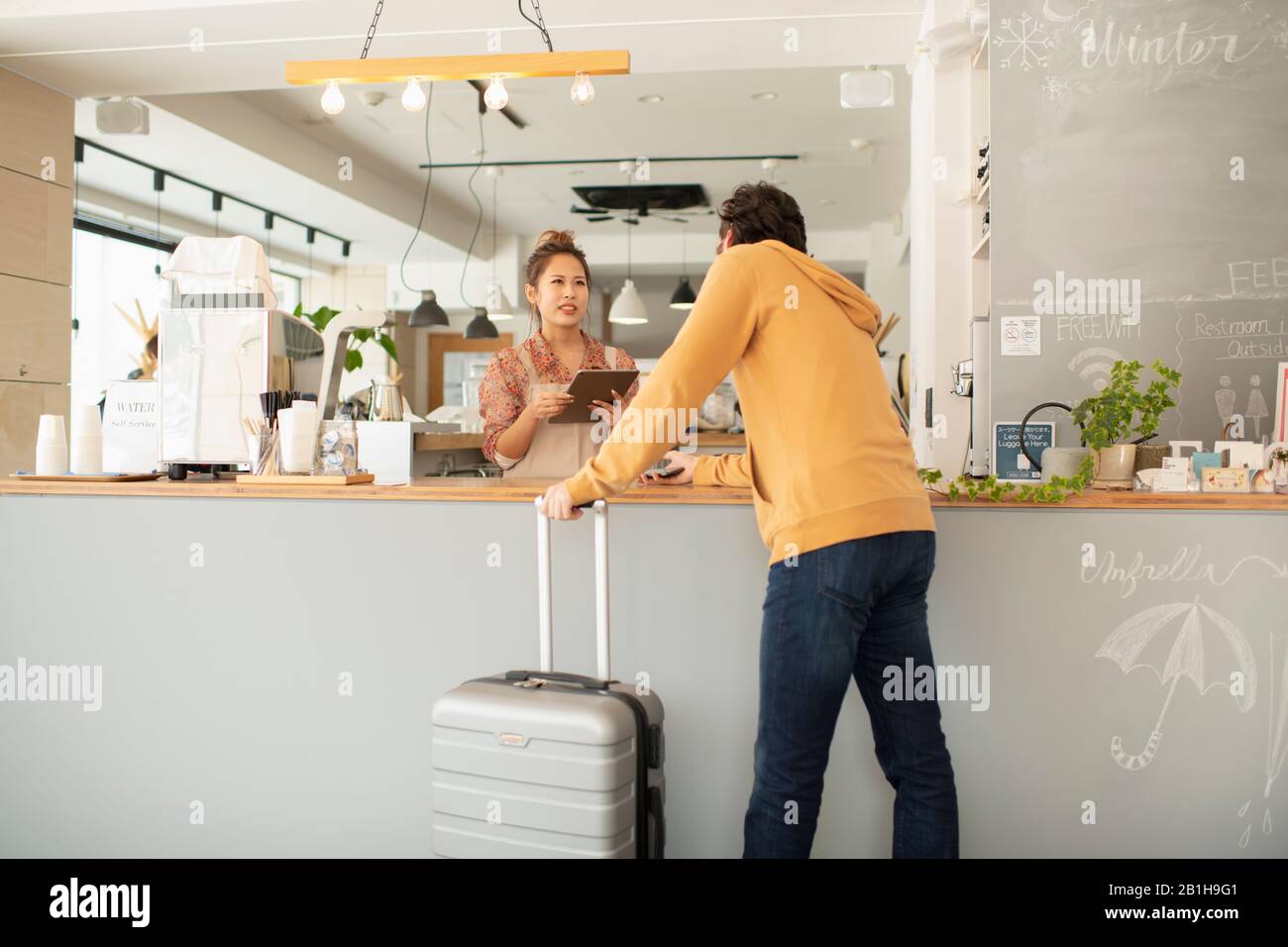Young woman attending foreign tourist Stock Photo - Alamy