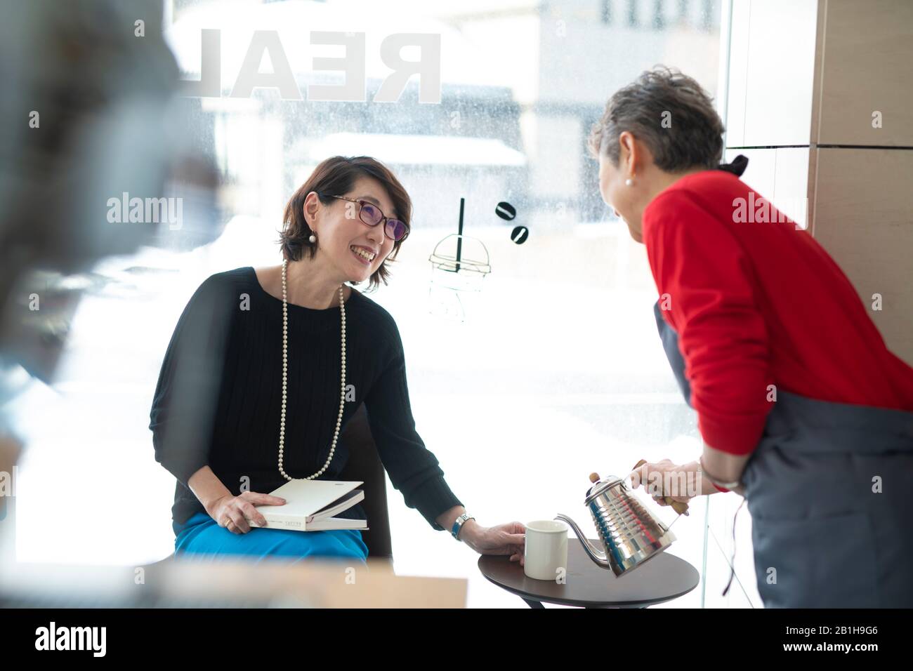 Shop clerk attending regular customer Stock Photo - Alamy