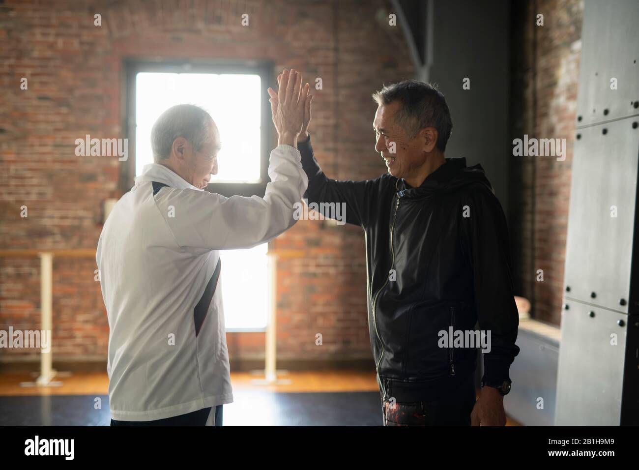 Two senior men doing hi-five Stock Photo - Alamy