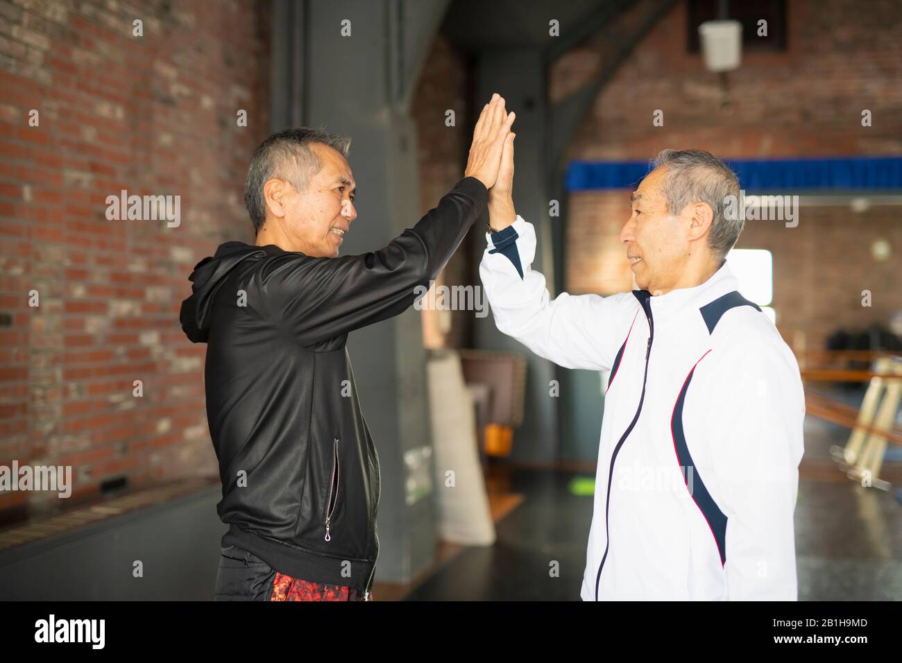 Two senior men doing hi-five Stock Photo - Alamy