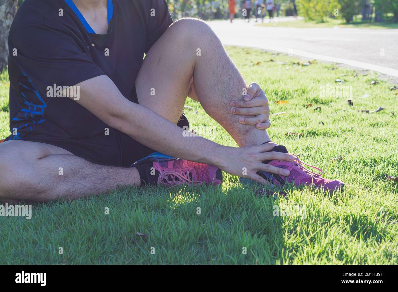 Ankle sprained. Young man suffering from an ankle injury while running ...