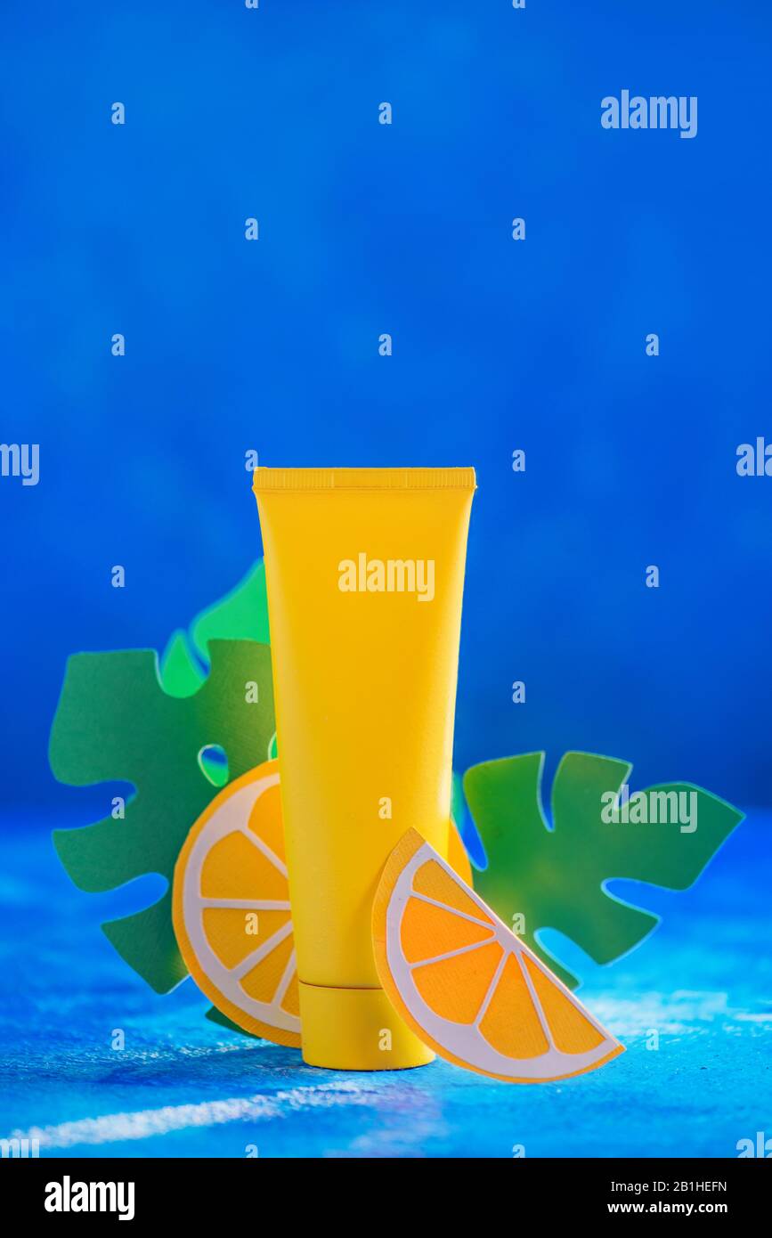 Yellow cream tube with tropical leaves, summer skincare concept with ...