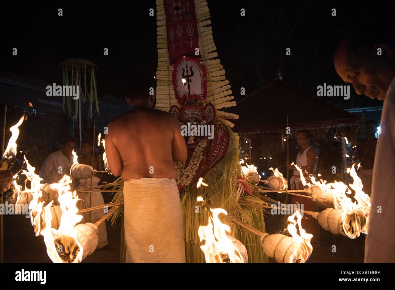 Theyyam performer, surrounded by torches, dances a popular ritual form ...