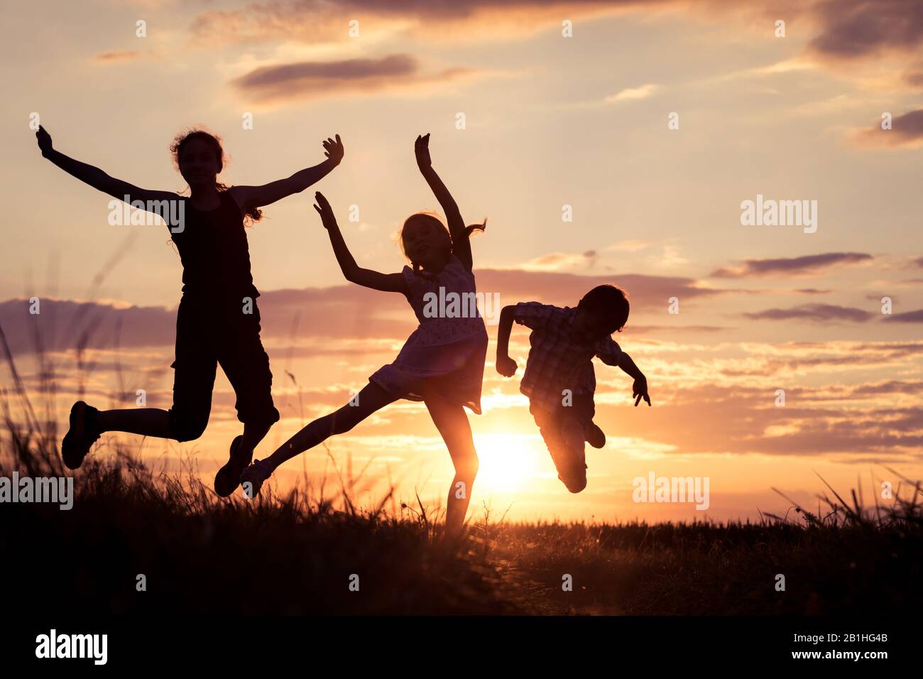 Happy children playing in the park at the sunset time. People having ...