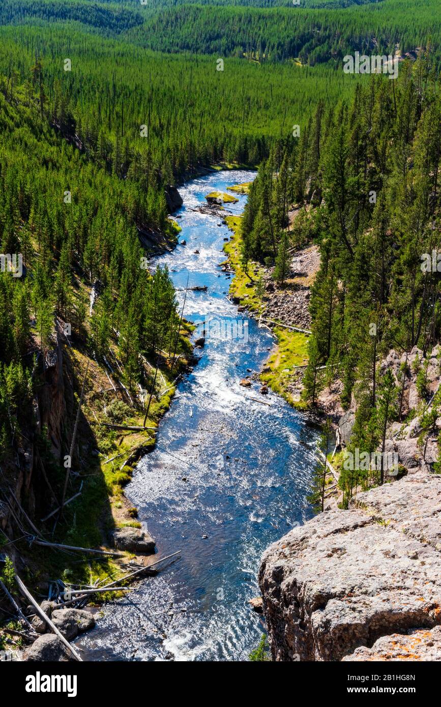 Looking over cliff at river running through green forest valley Stock ...