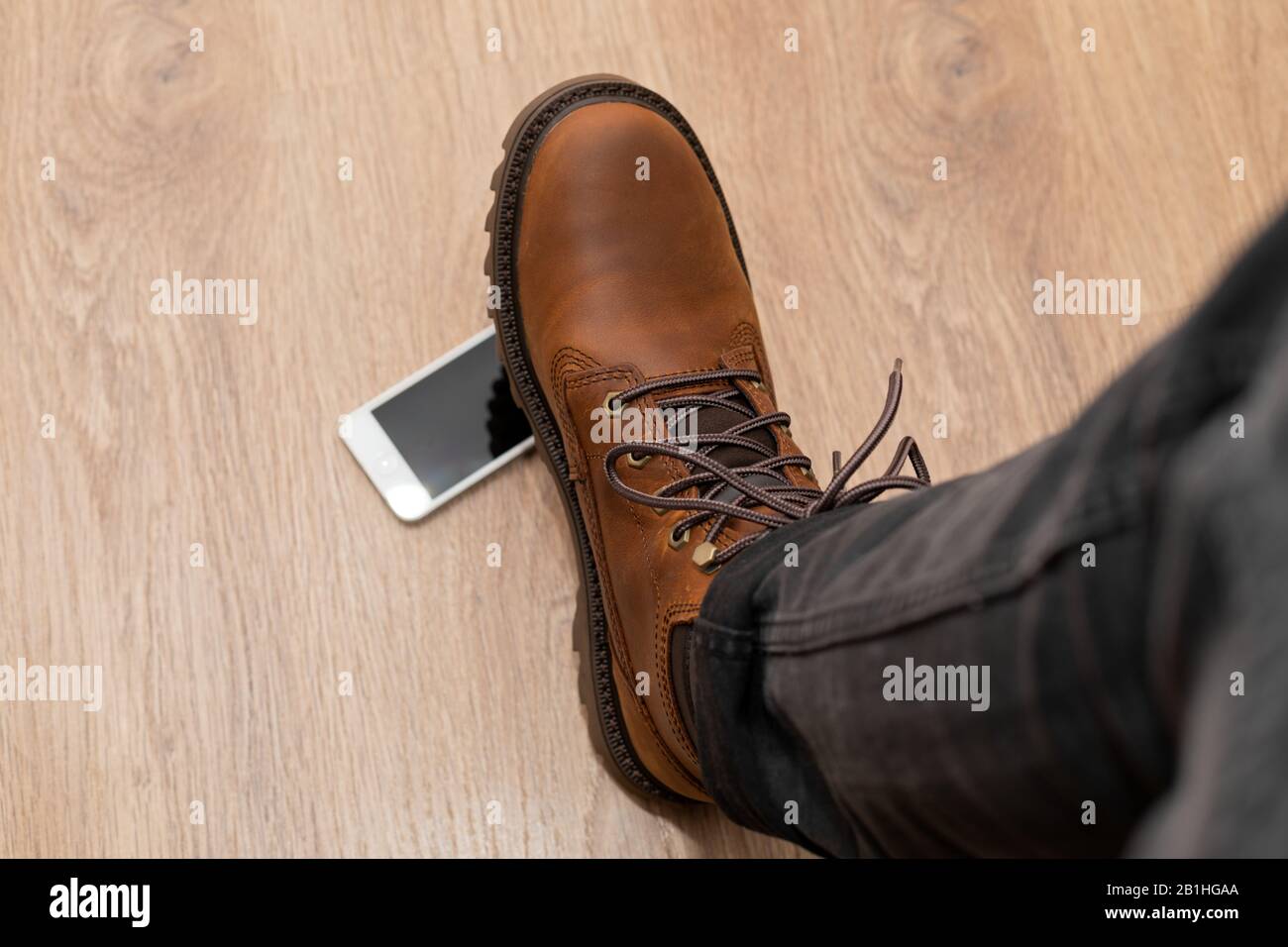 Picture of a men's boot steps on a smartphone Stock Photo - Alamy