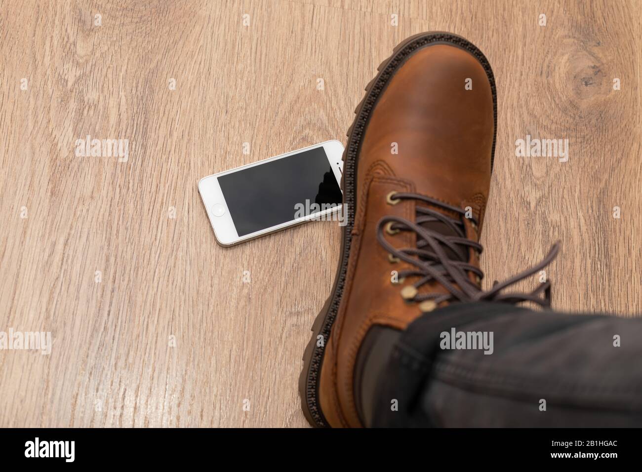 Picture of a men's boot steps on a smartphone Stock Photo - Alamy