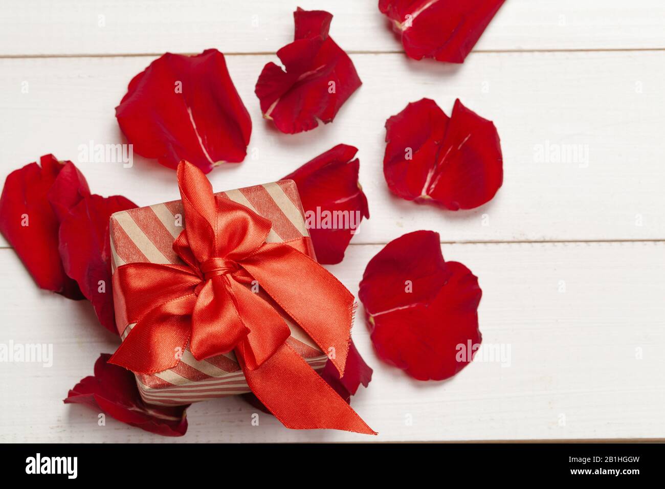 Gift box and rose petal on white background Stock Photo - Alamy
