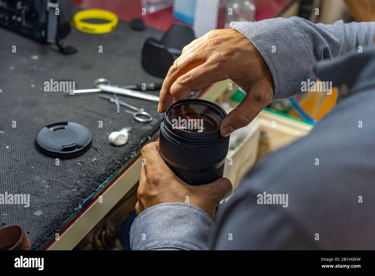 Closeup photo of technician with amputated finger cleaning camera lens ...