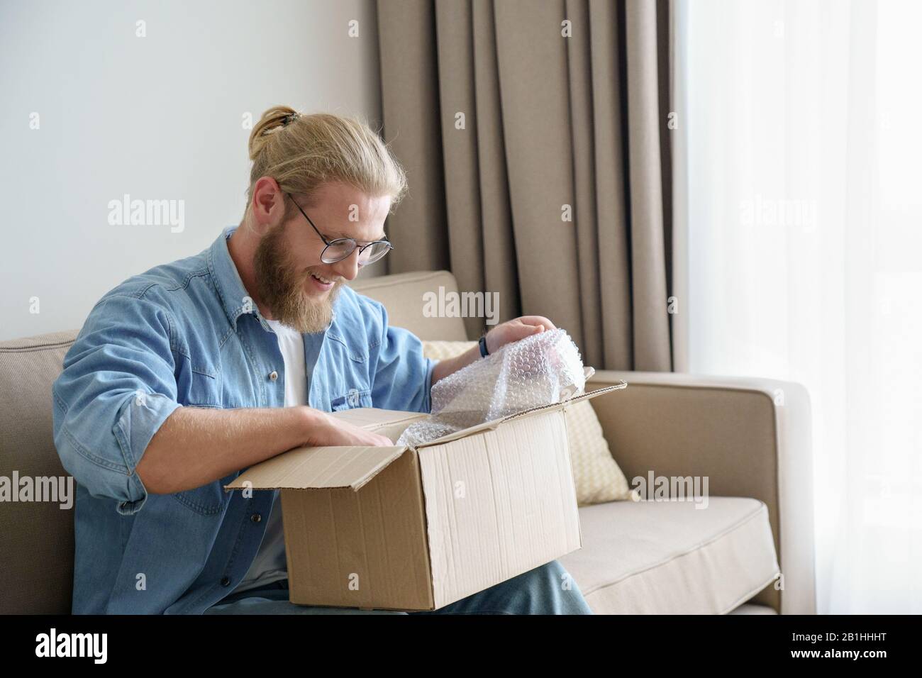 Happy male customer open cardboard box receive postal mail delivery ...