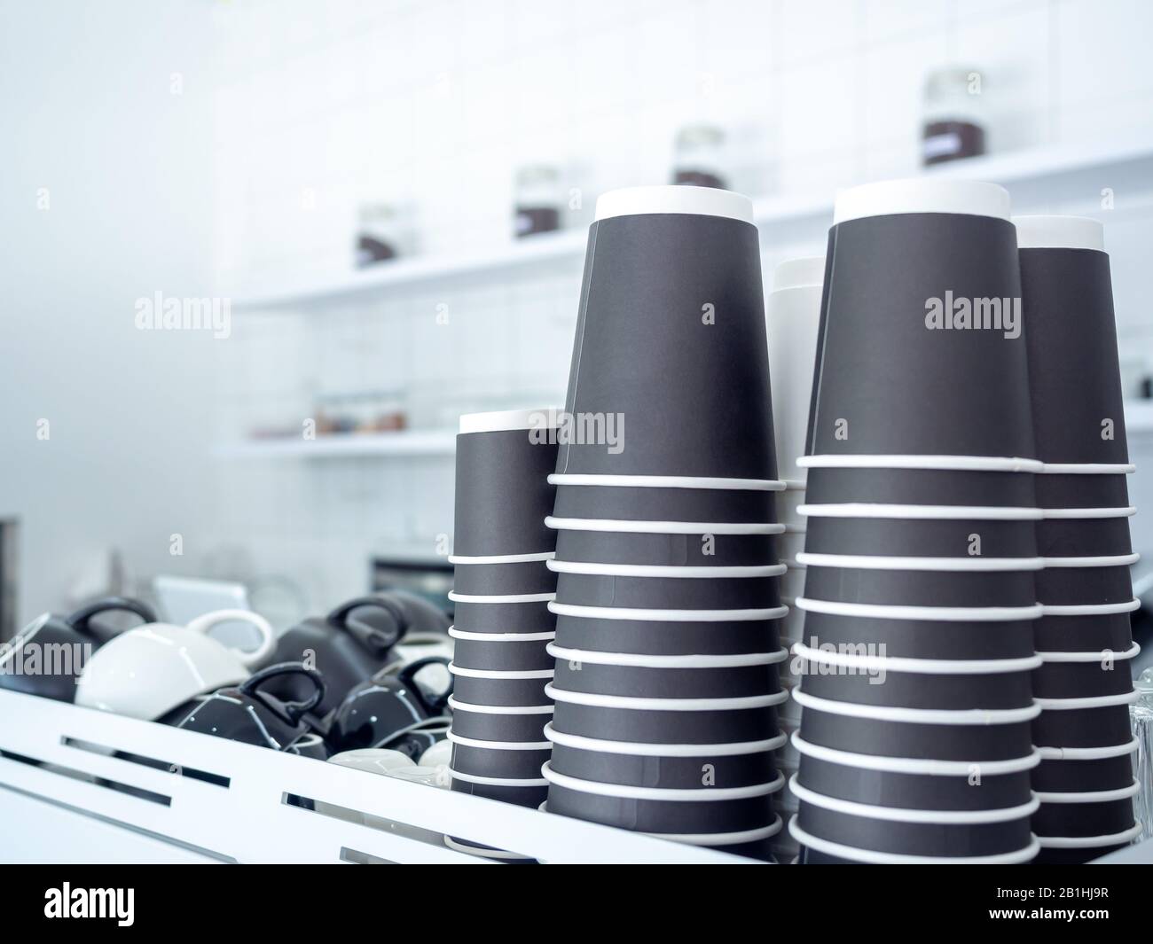 Black paper coffee cups stacked in a pile. Row of black paper cups ...