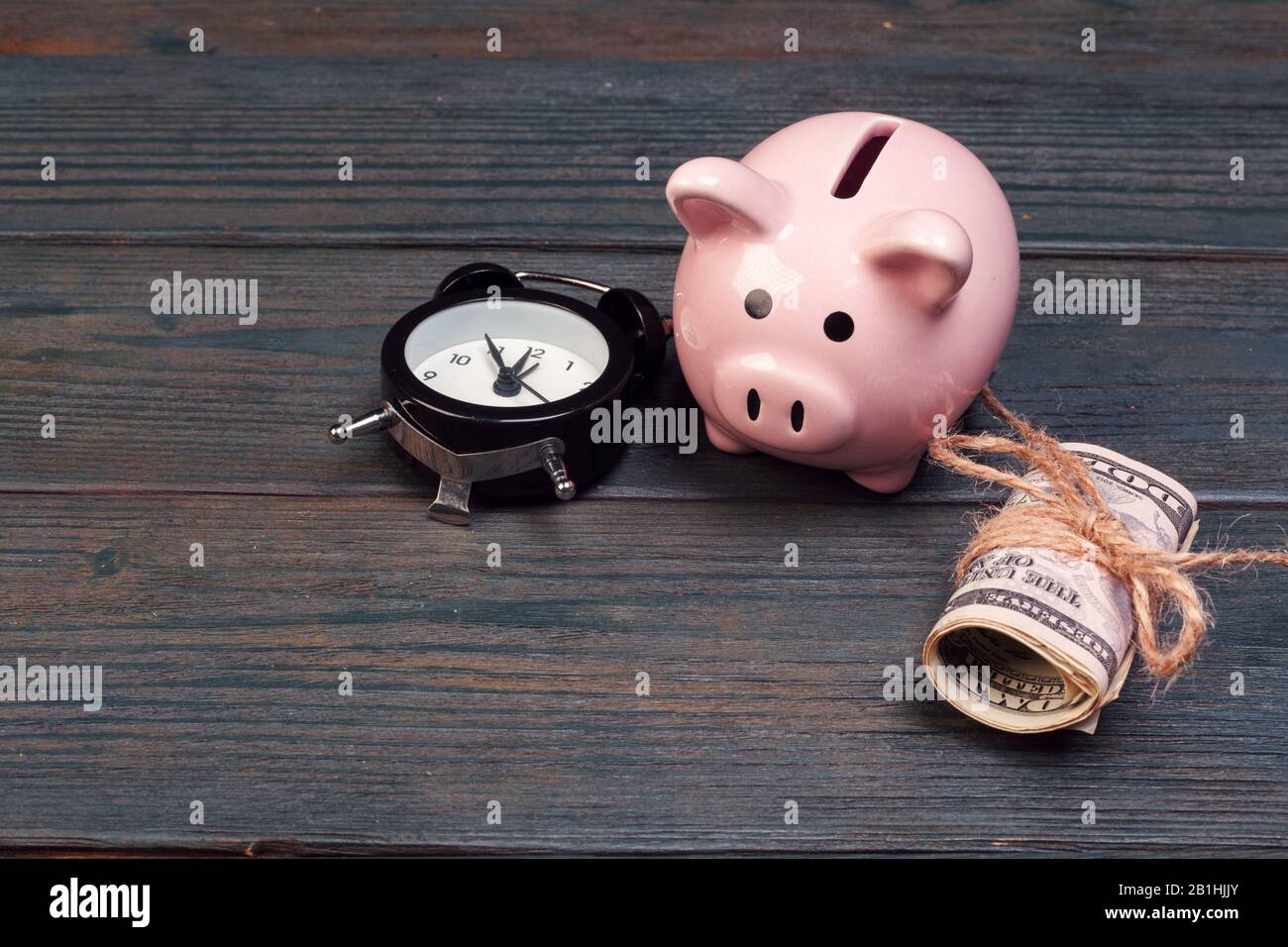 alarm clock piggy bank on old wood background Stock Photo - Alamy