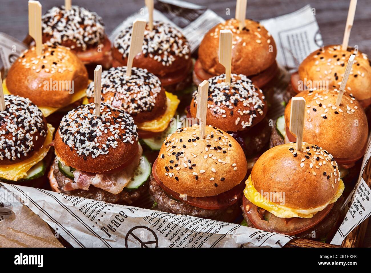 A large set of many hamburgers, cheeseburgers laid out on the table ...