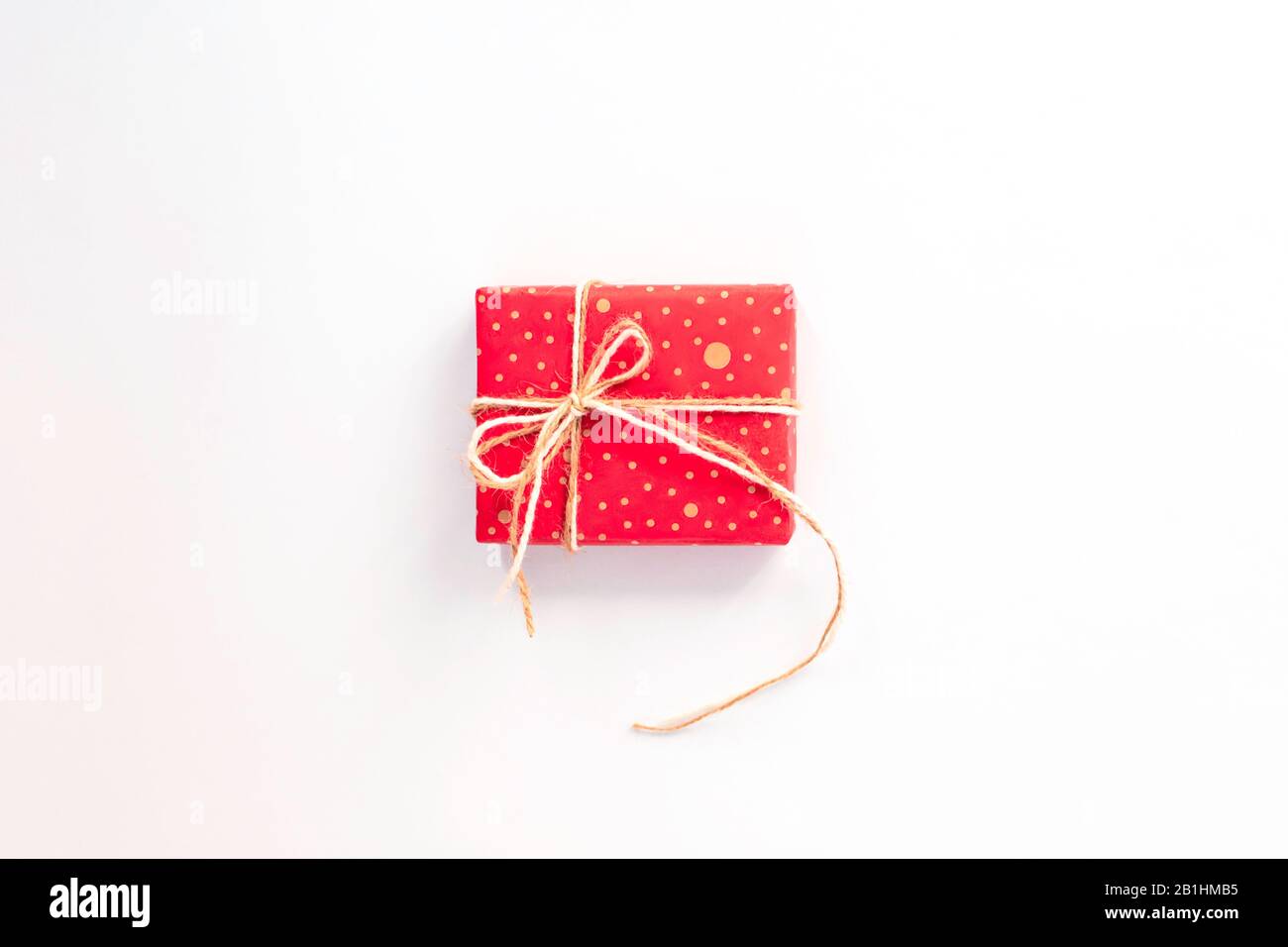 Craft gift box in red wrapping paper with craft ribbon on the white ...