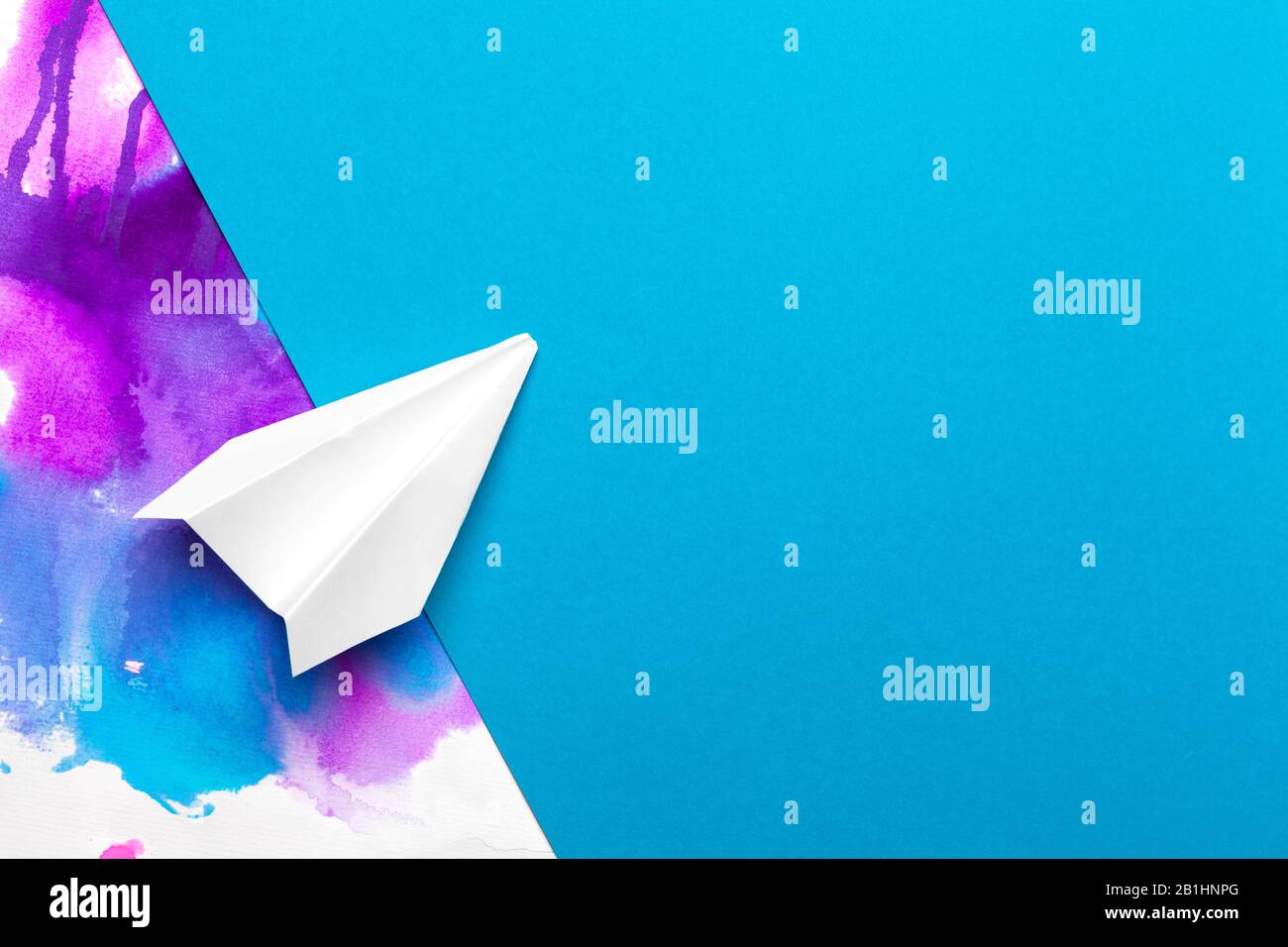 white paper airplane on a color block paper background. Creative photo ...