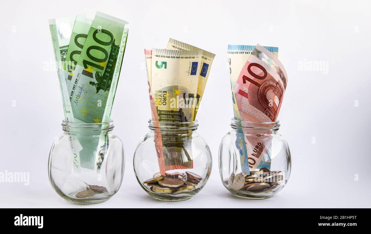Glass jars filled with coins and Euro bills, savings inside glass jar ...