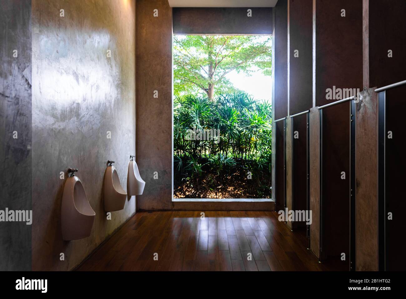 White urinals in clean men public toilet room empty with big window and ...