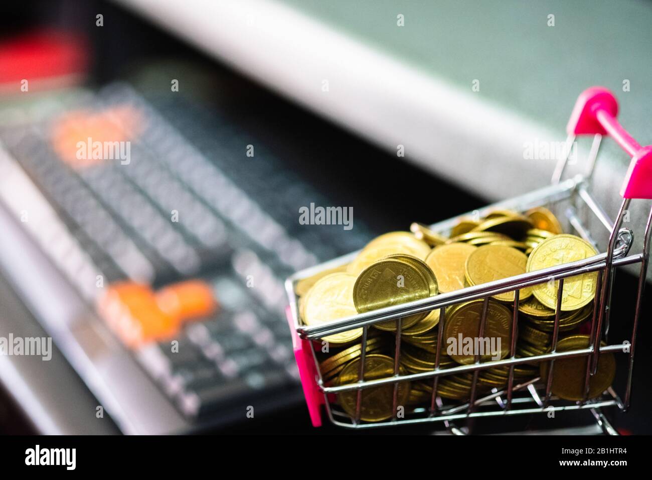 Coins in supermarket cart trolley with computer and keyboard for online ...