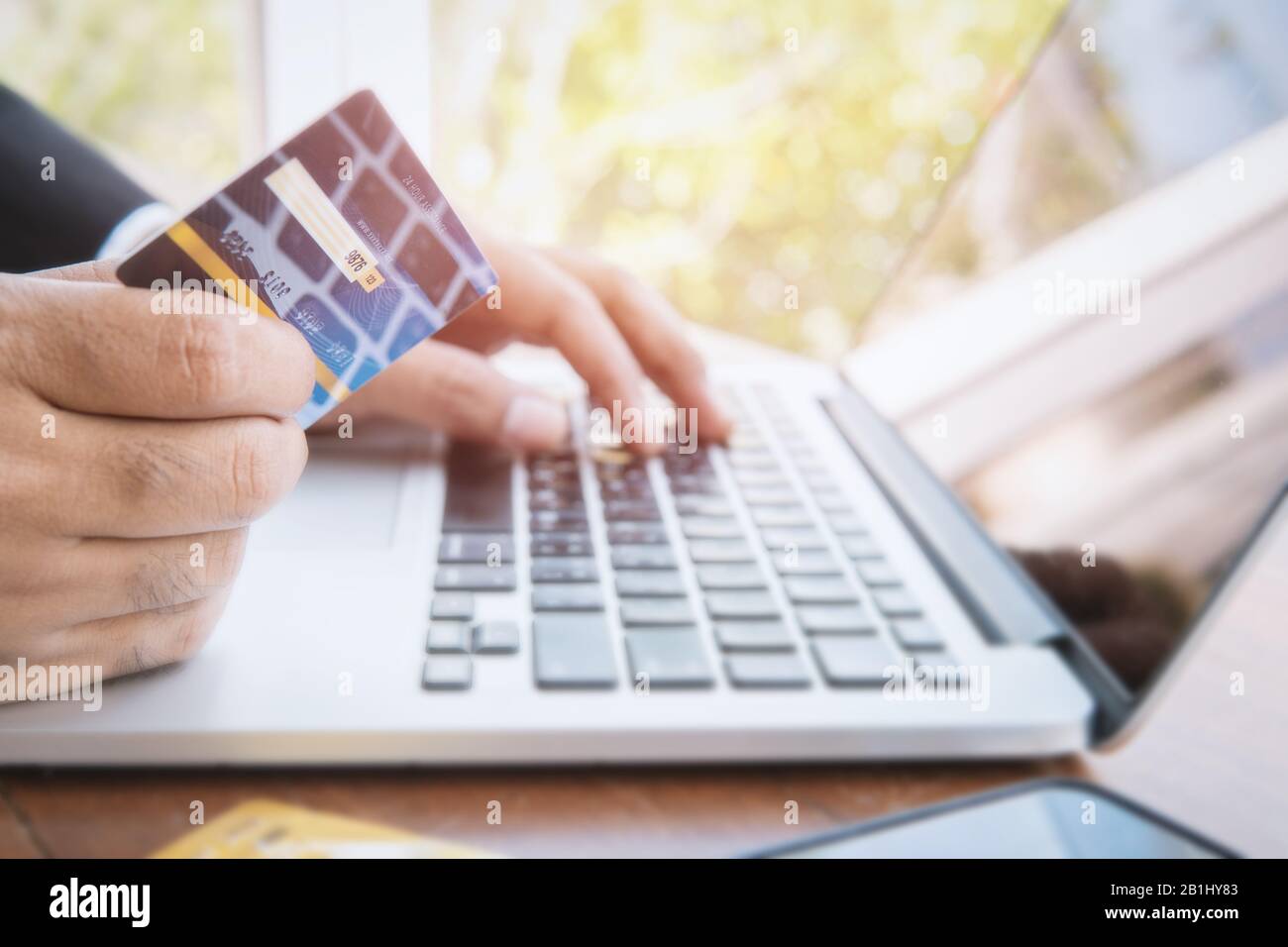 Business man hand hold credit card to shopping internet online bill on ...