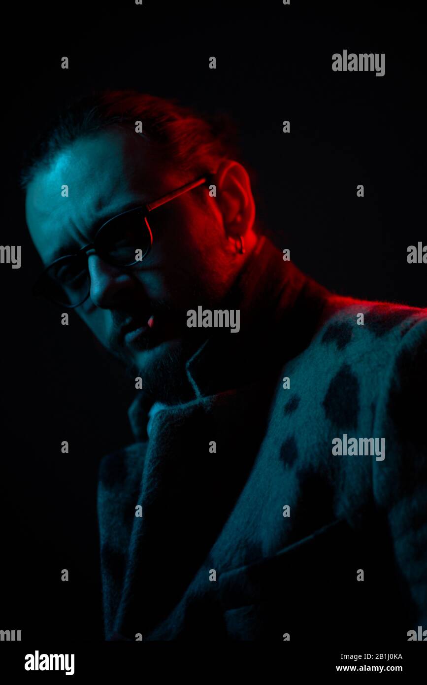 Man with toothpick in mouth, beard in glasses on black background Stock ...