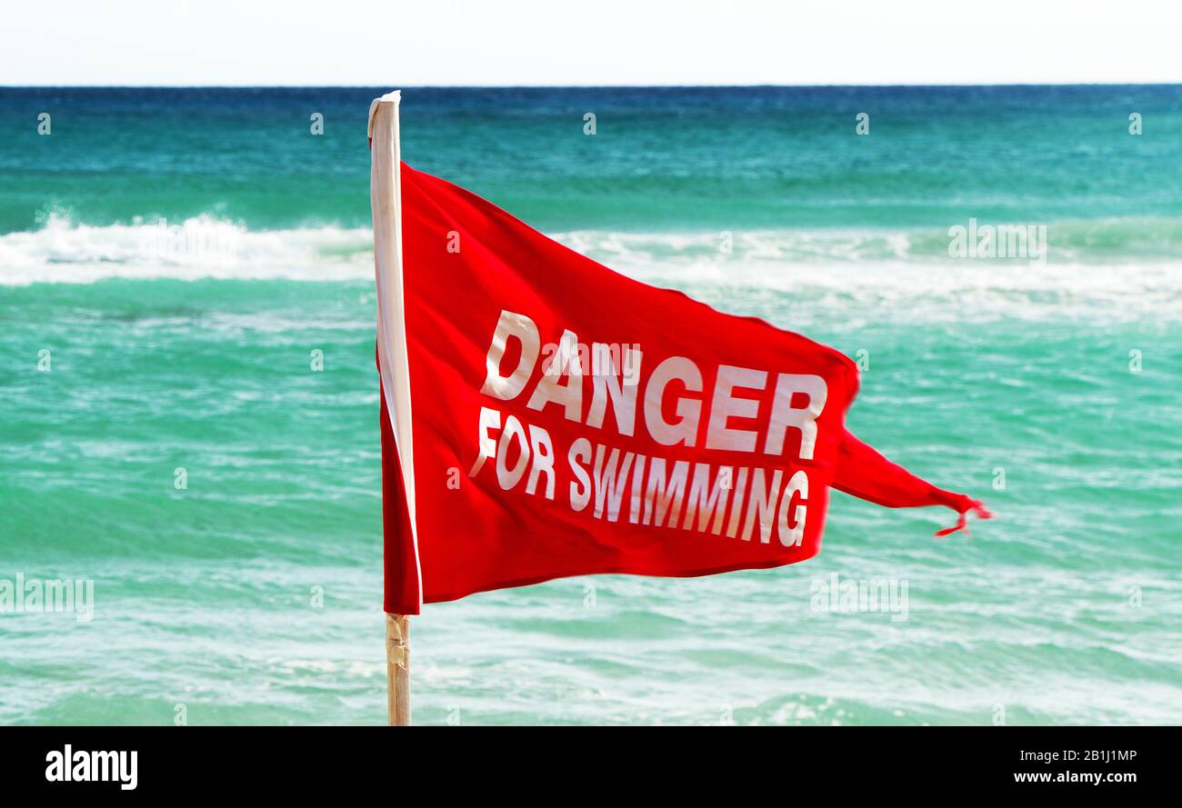 Danger for swimming red flag on the beach Stock Photo - Alamy