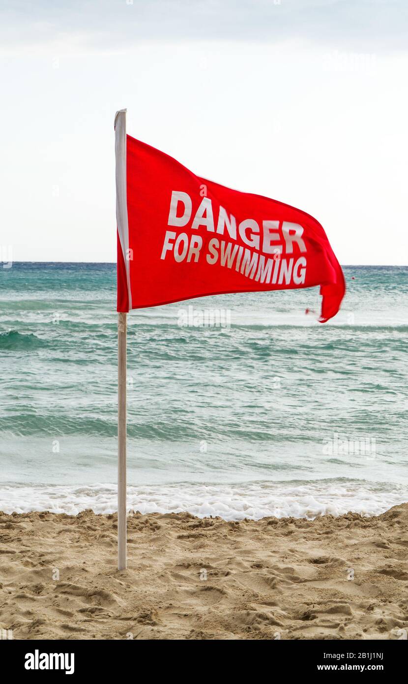 Danger for swimming red flag on the beach Stock Photo - Alamy
