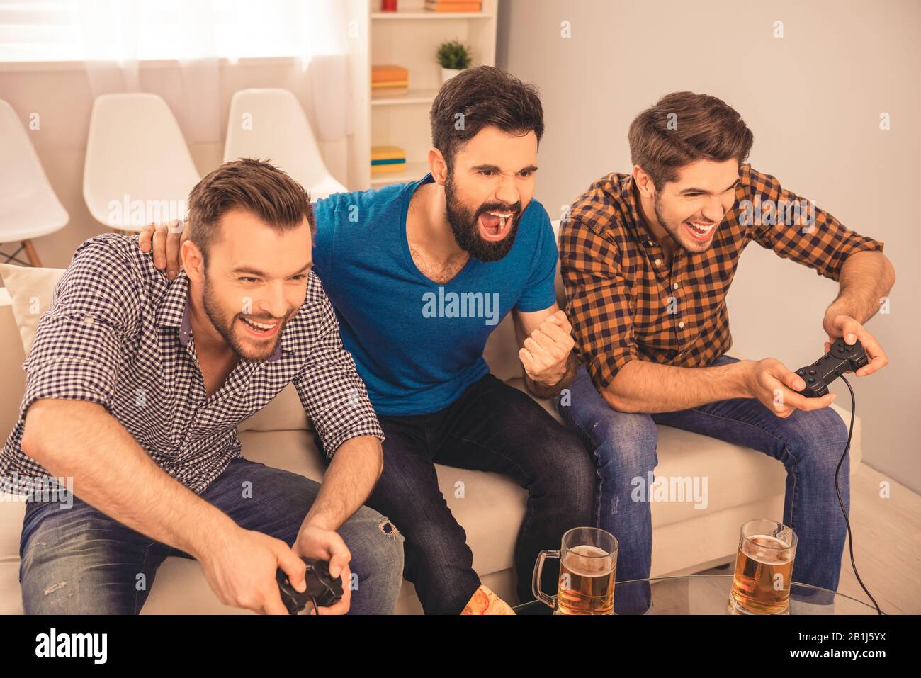 Portrait of happy handsome men playing video game with his friends ...