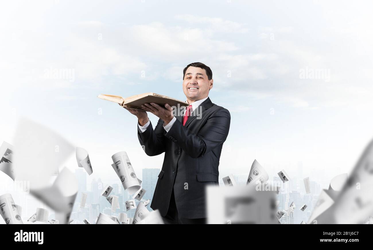 Happy businessman holding open book Stock Photo - Alamy