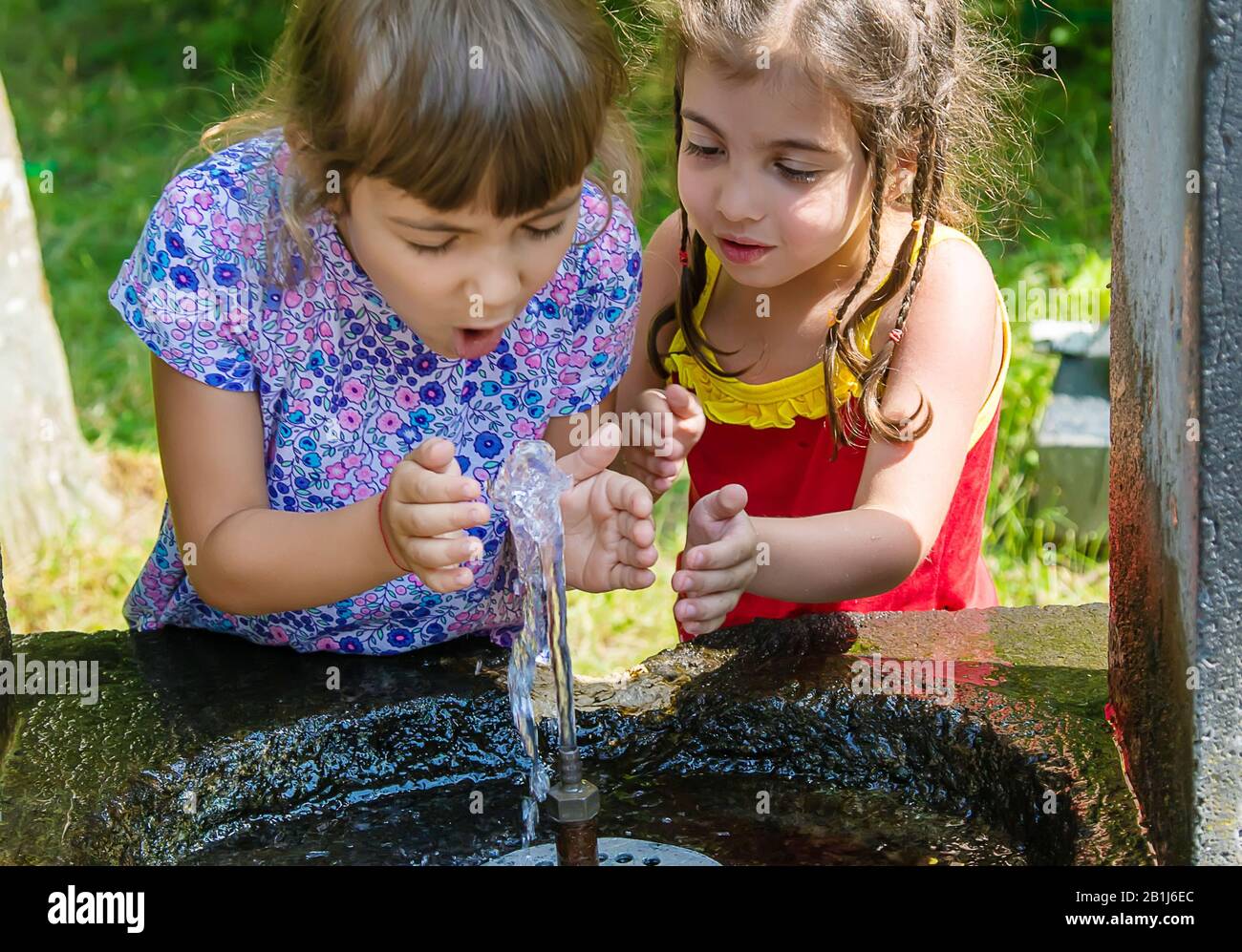 children drink water from a spring in Borjomi, Georgia. Selective focus ...