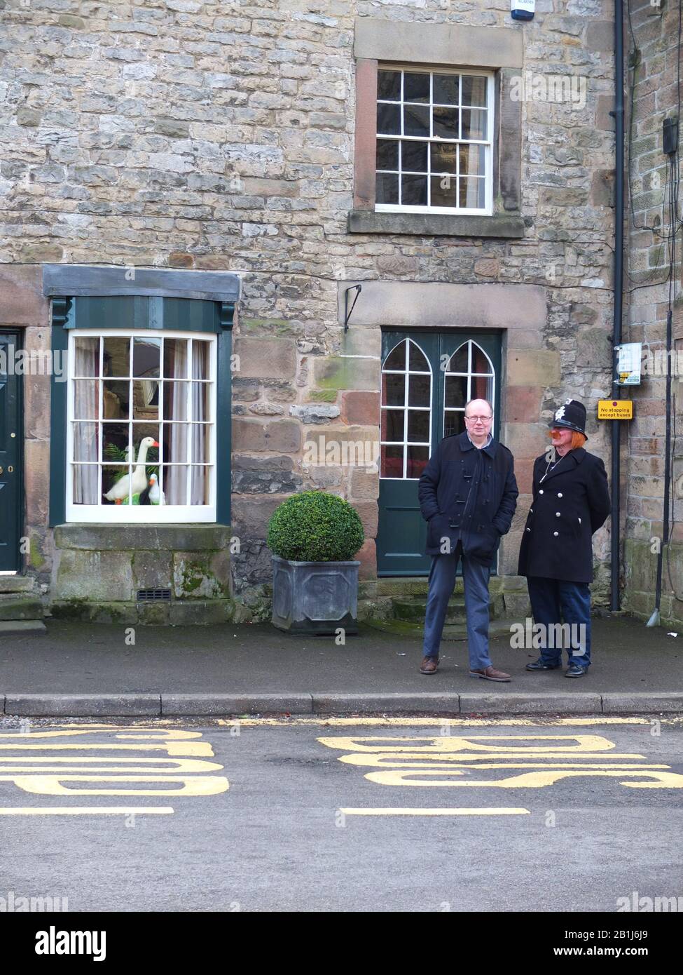 Comic policeman character in fancy dress & villager prior to start of ...