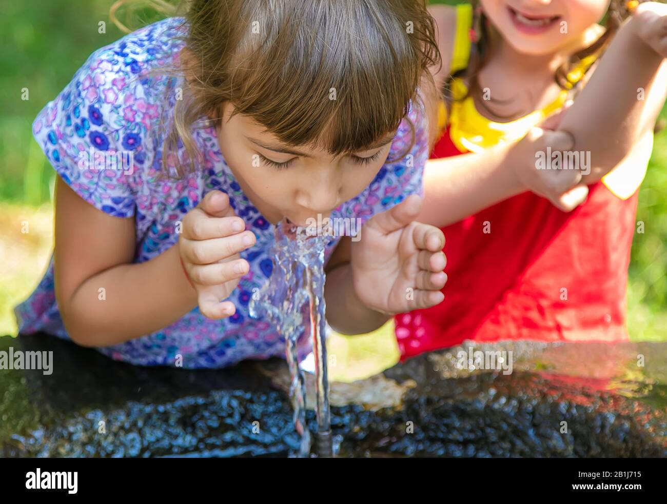 children drink water from a spring in Borjomi, Georgia. Selective focus ...