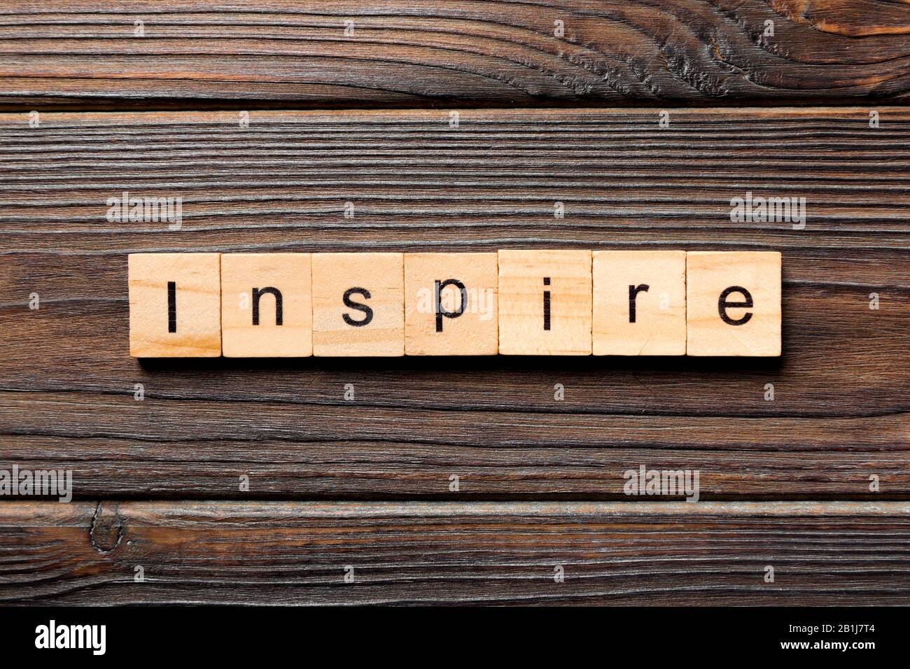 Inspire word written on wood block. Inspire text on wooden table for ...